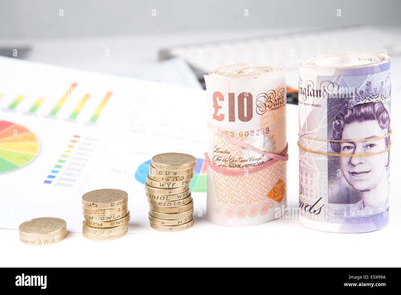 British pound coins and notes with financial chart Stock Photo - Alamy