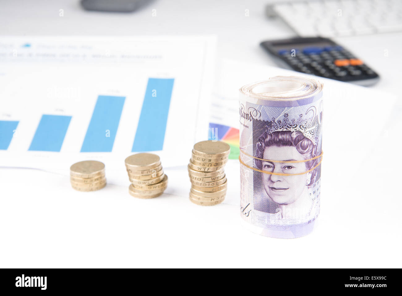 British pound coins and notes with financial chart Stock Photo - Alamy
