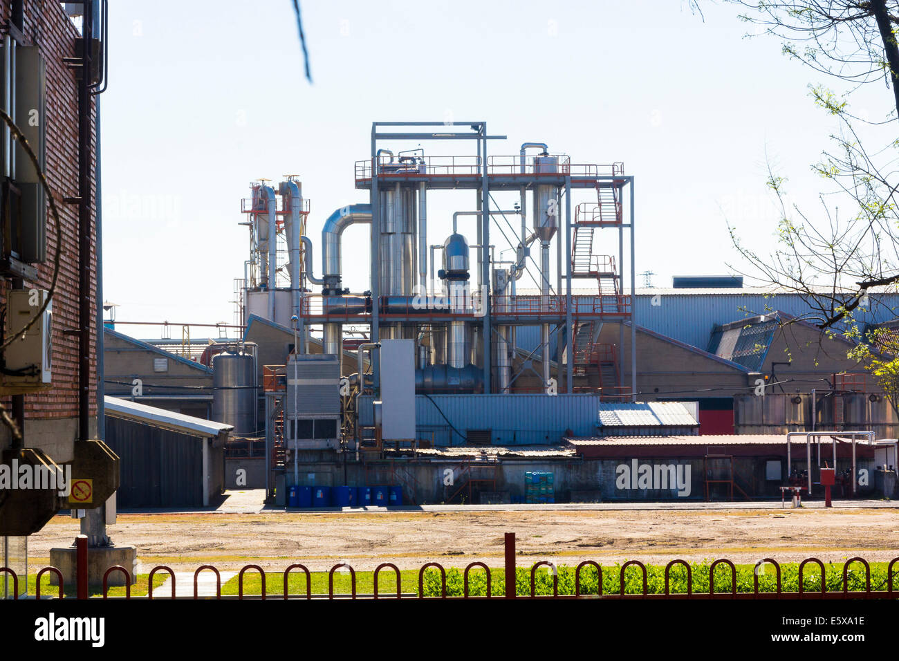 metal deposits and a small factory chimneys Stock Photo - Alamy
