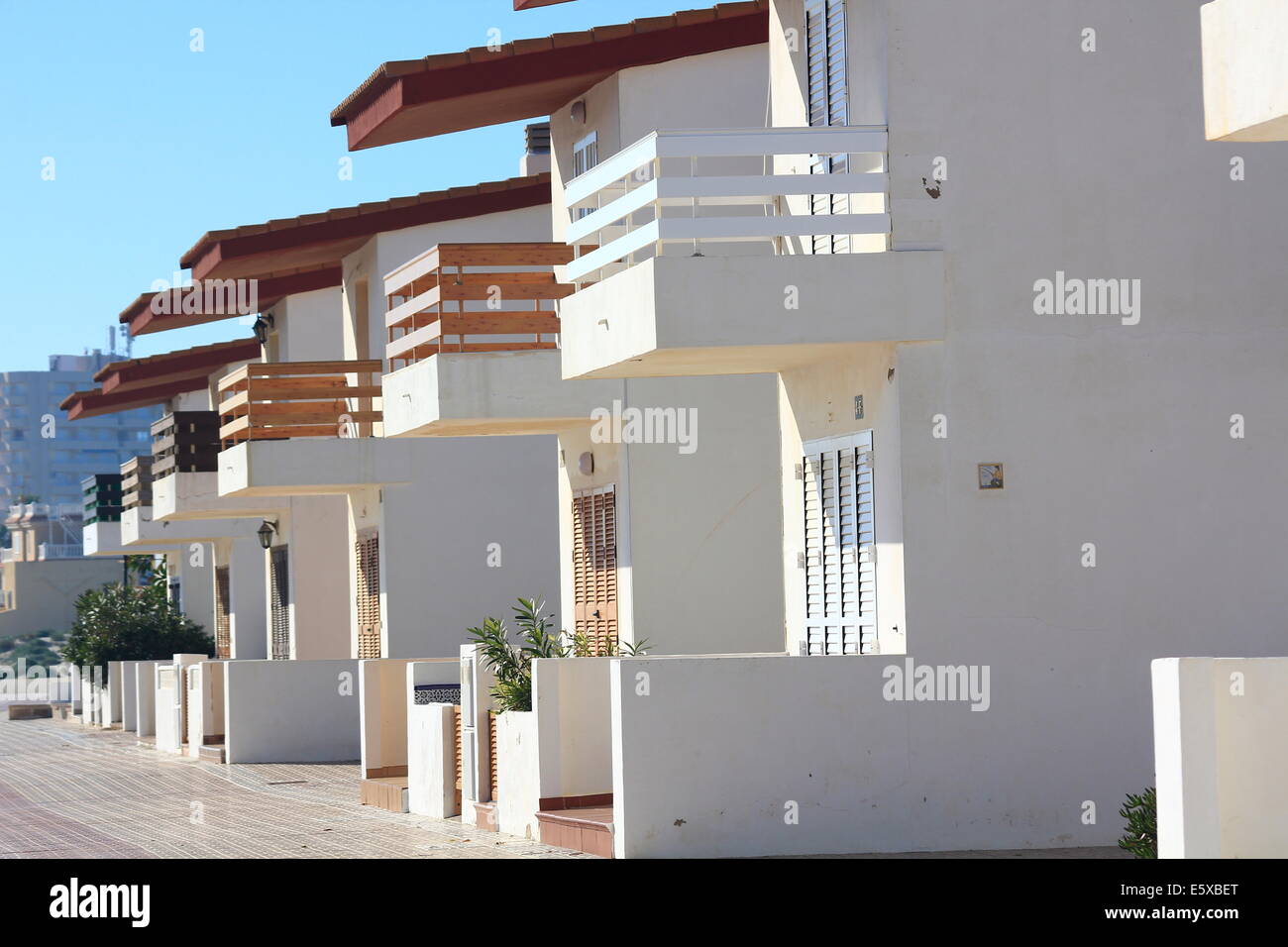 row of small white color apartments Stock Photo - Alamy