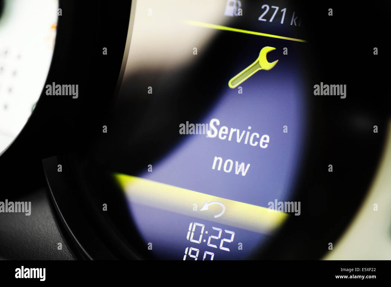 Detail with a warning icon on the dashboard of a car reading "Service ...