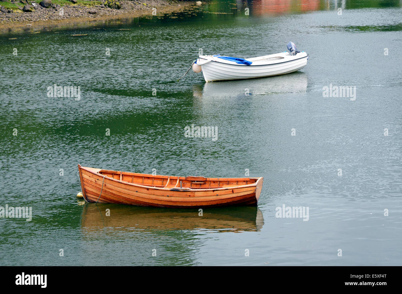 A small clinker built wooden rowing boat and modern fibreglass type ...