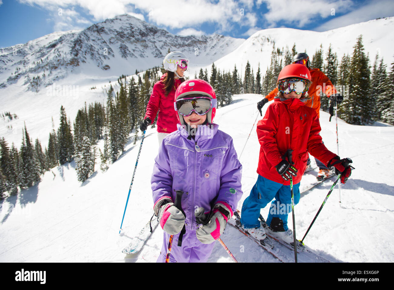 A family of skiers pose at the top of the mountain in Snowbird, Utah ...