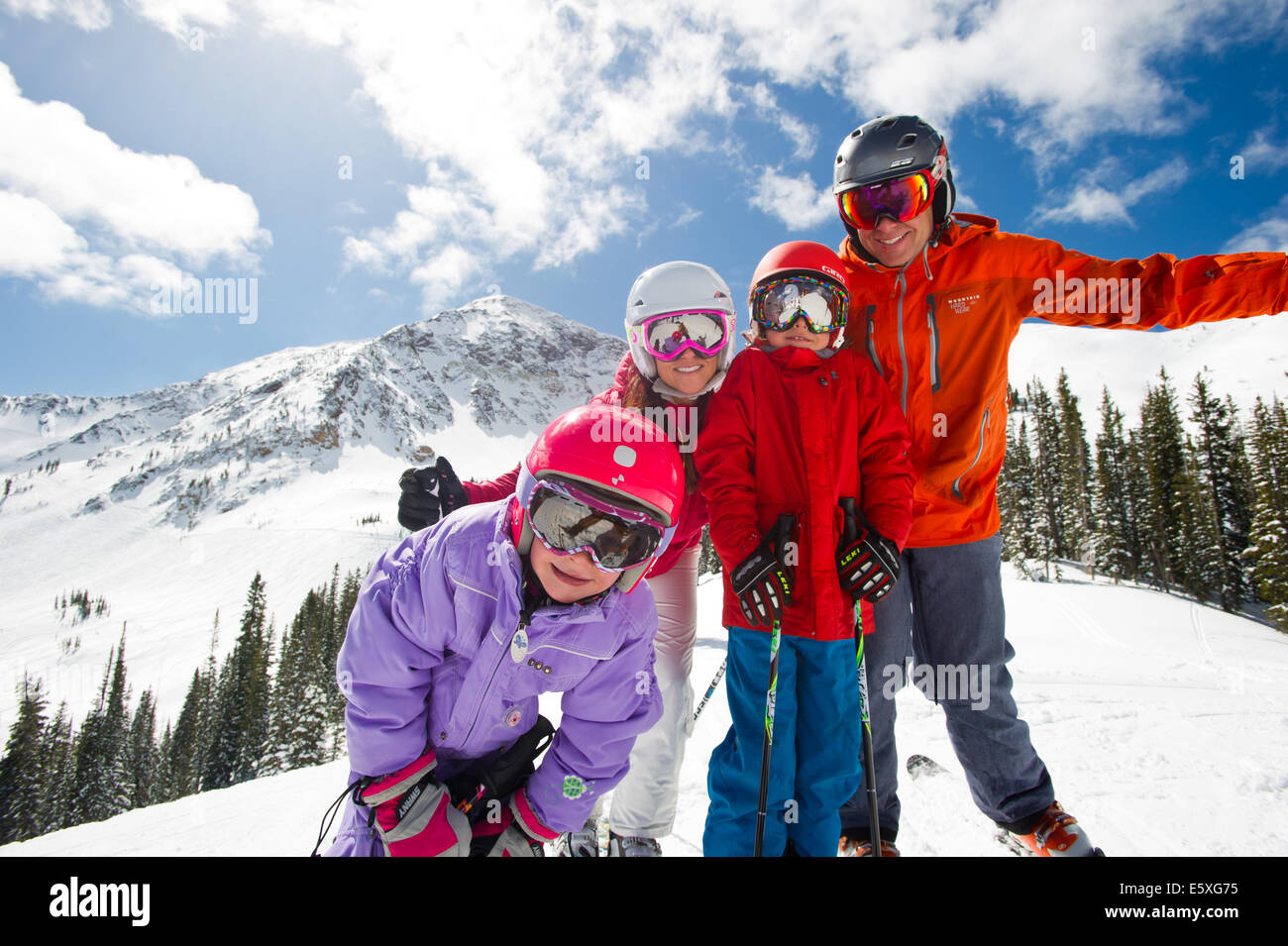 A family of skiers pose at the top of the mountain in Snowbird, Utah ...