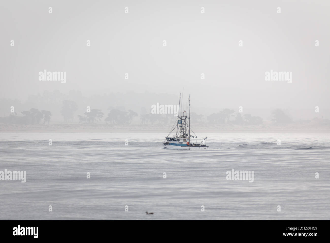 Fishing boat in morning mist Stock Photo - Alamy