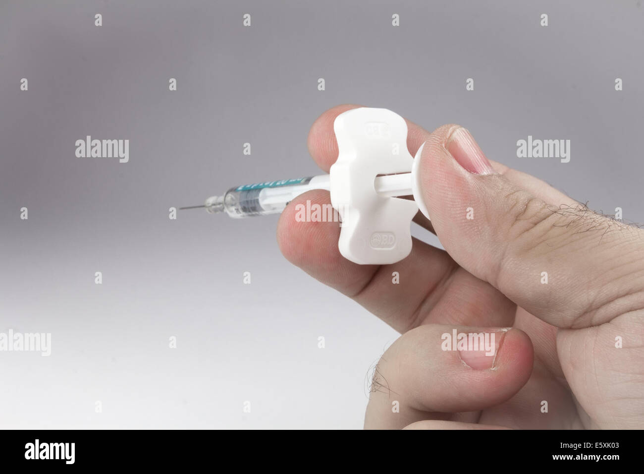 Hand with a syringe in position to inject Stock Photo - Alamy