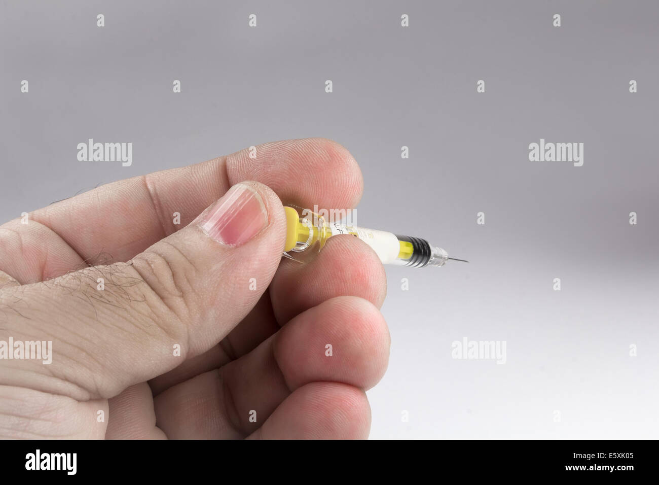 Hand with a syringe in position to inject Stock Photo - Alamy