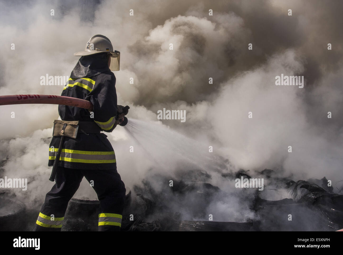 Kiev, Ukrain. 7yh Aug, 2014. Firefighters extinguish a barricade of ...