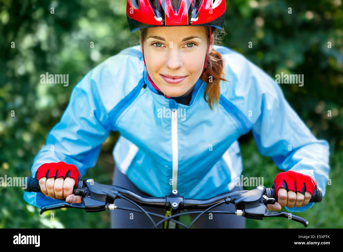 Happy Young woman leaned over the handlebars of her bike Stock Photo ...