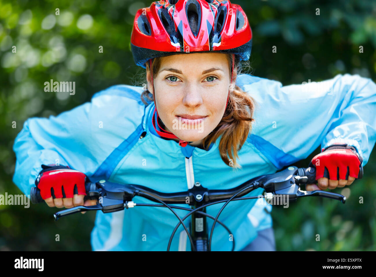 Happy Young woman leaned over the handlebars of her bike Stock Photo ...