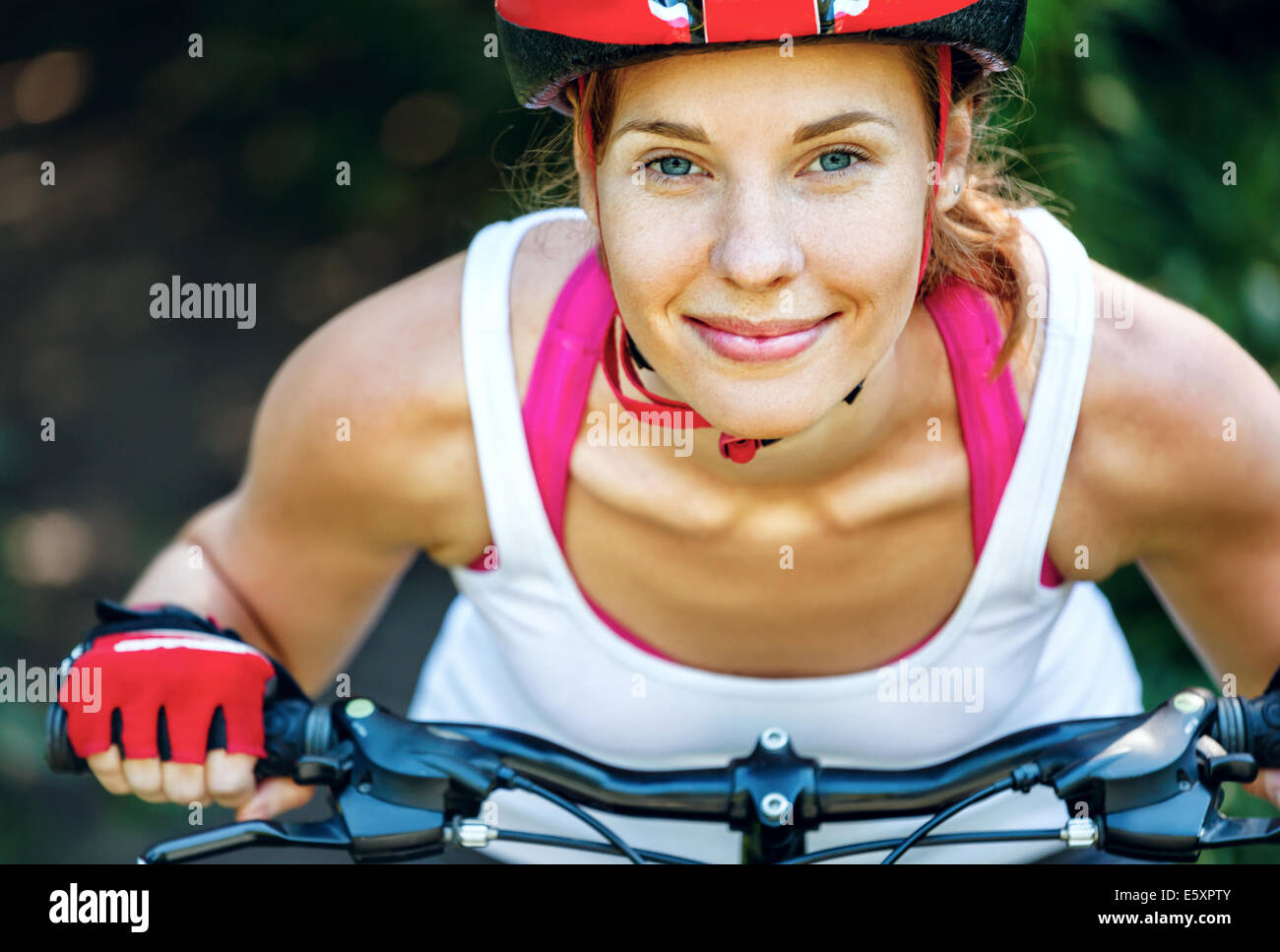 Happy Young woman leaned over the handlebars of her bike Stock Photo ...