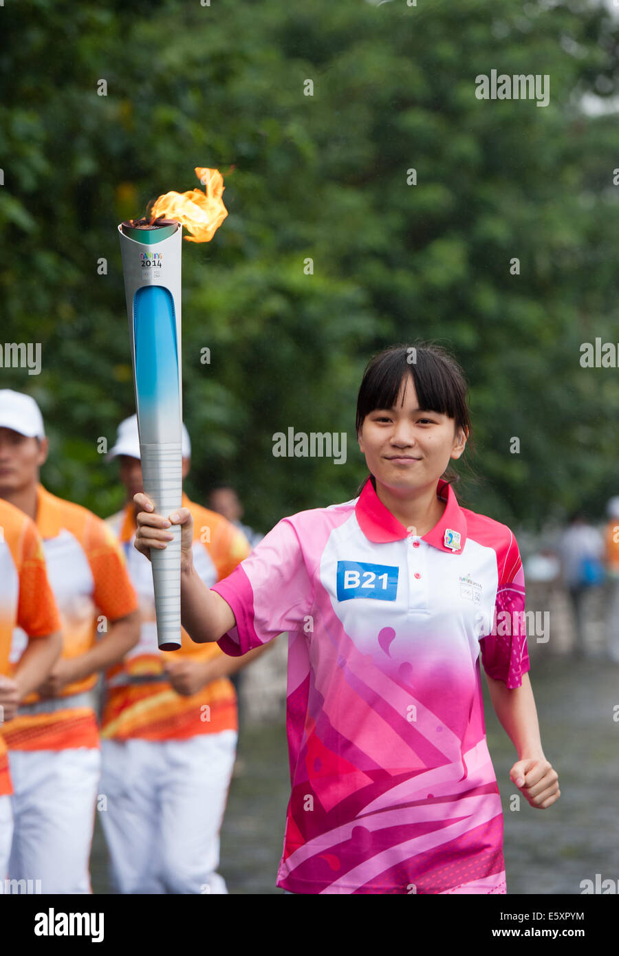 Nanjing, China's Jiangsu Province. 8th Aug, 2014. Torch bearer Zhao Li runs with the Olympic ...