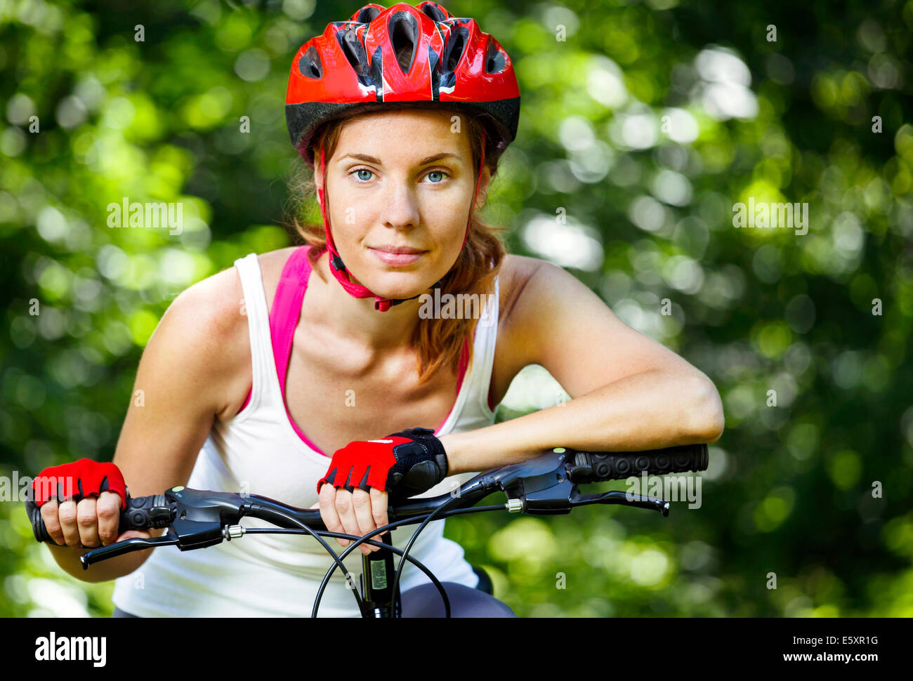 Happy Young woman leaned over the handlebars of her bike Stock Photo ...