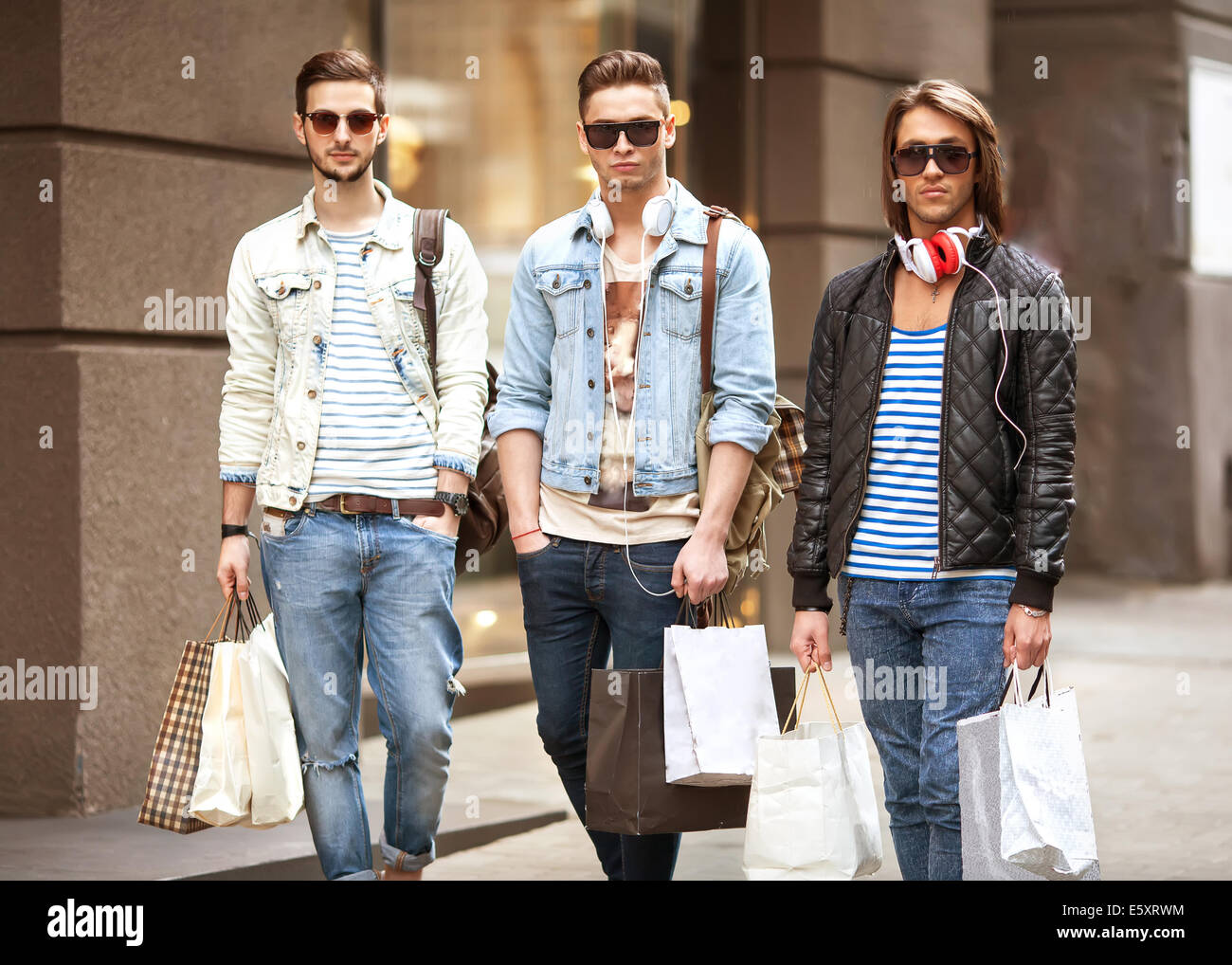 Three Young male fashion shop shopping walk Stock Photo - Alamy