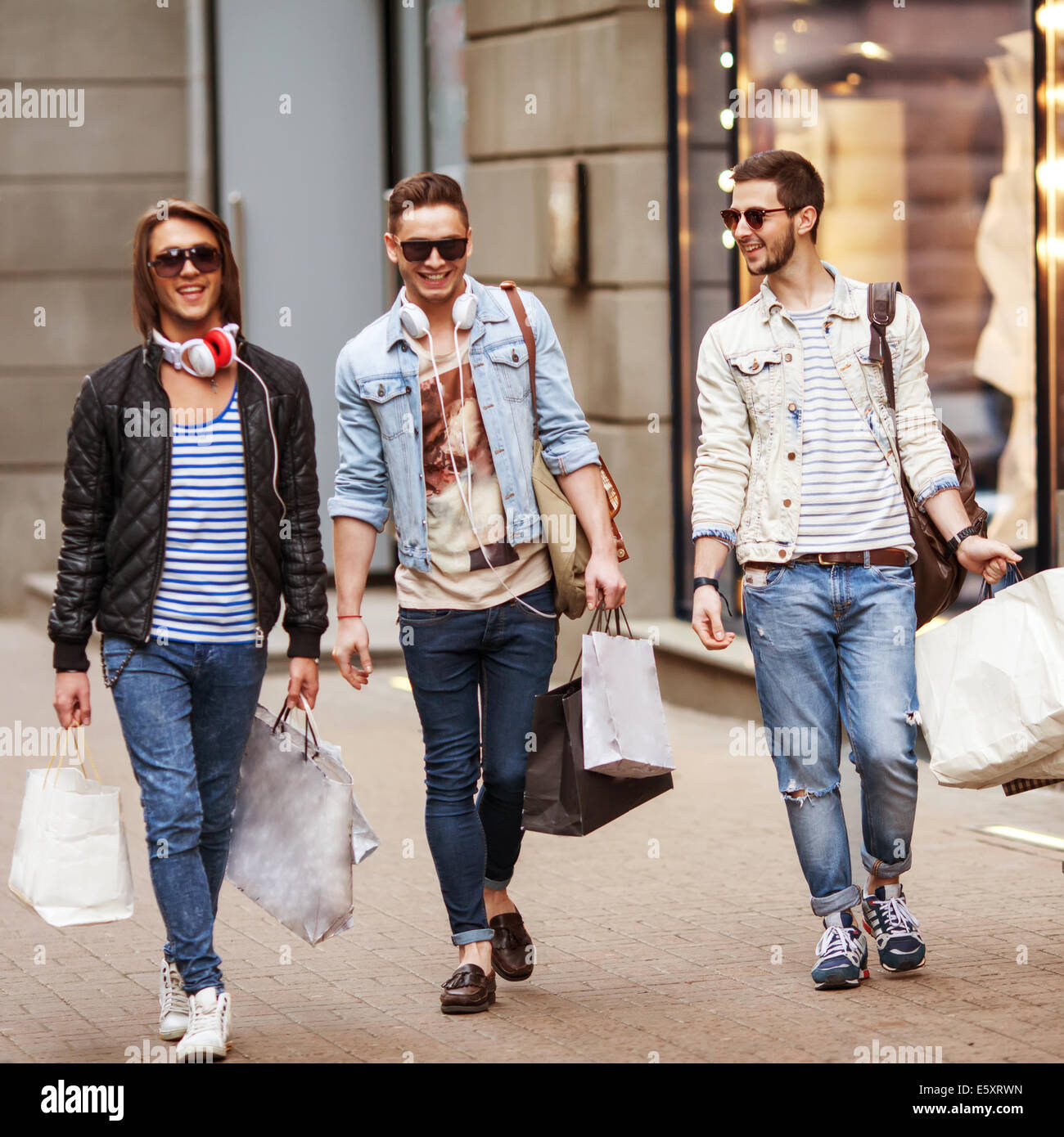 Three Young male fashion shop shopping walk Stock Photo - Alamy