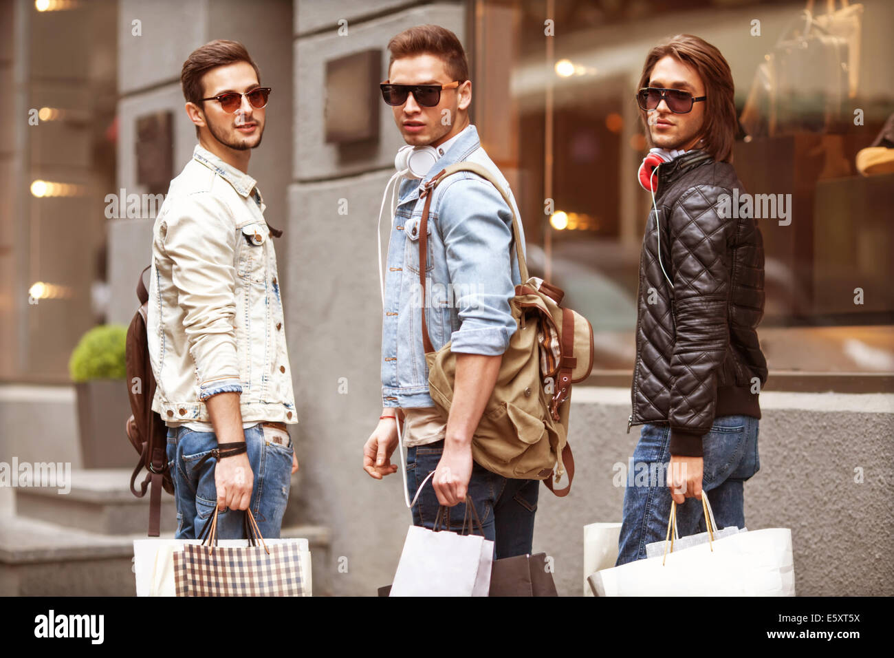 Three men fashion shop shopping walk Stock Photo - Alamy