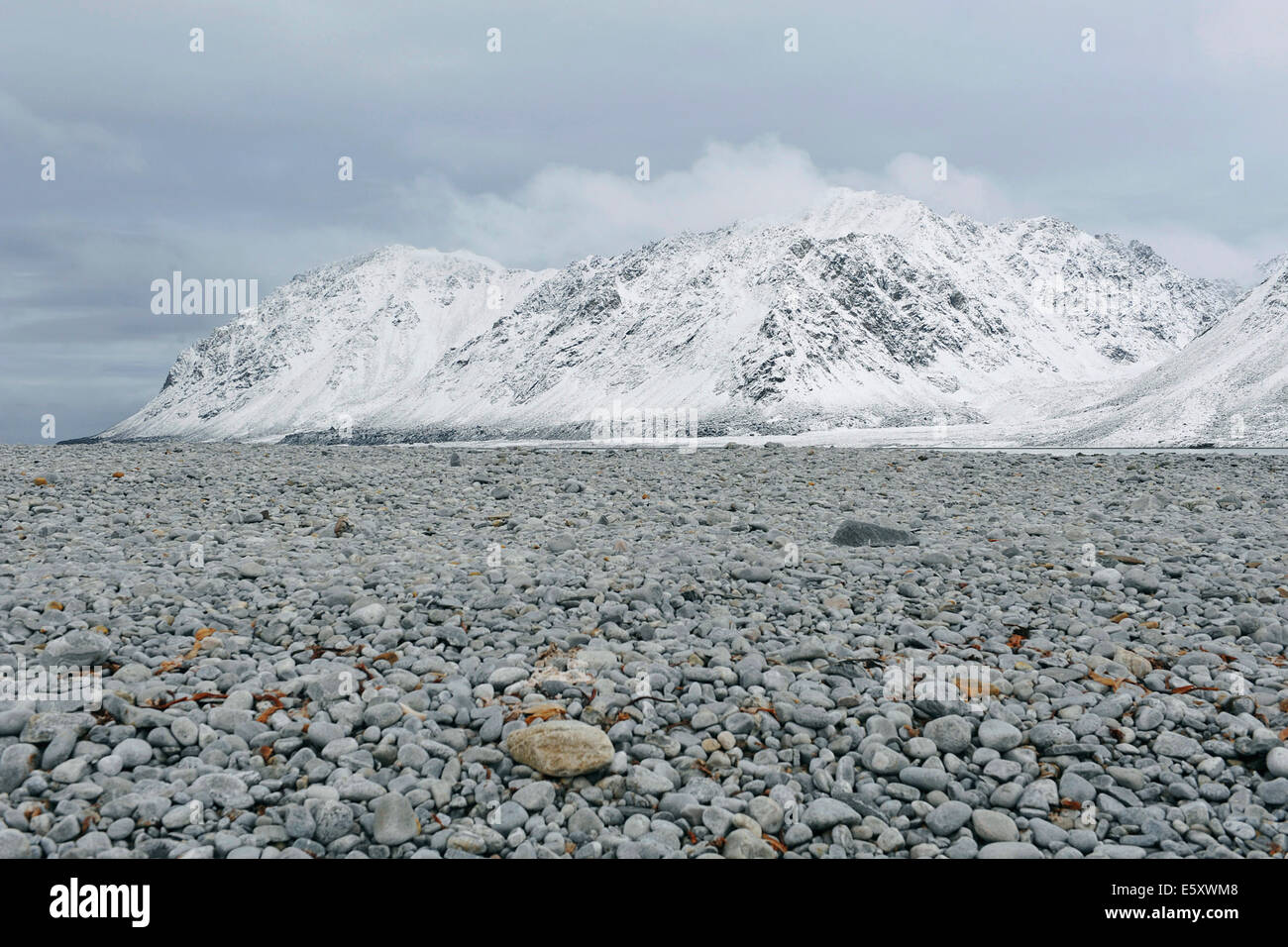 Big grey field of scree in front of a cloudy mountain range in the ...