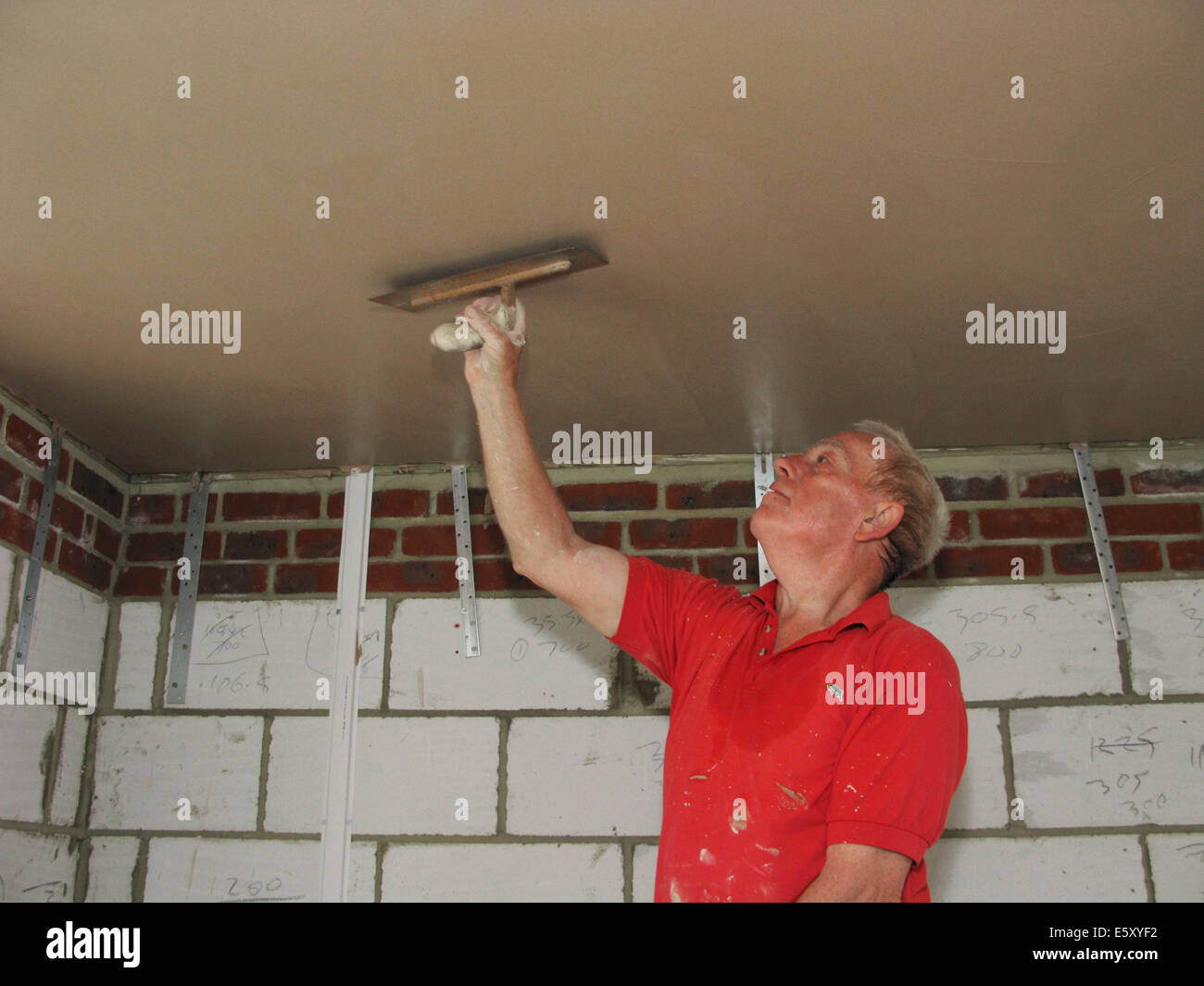 Plasterer plastering the ceiling of a newly built property / extension ...