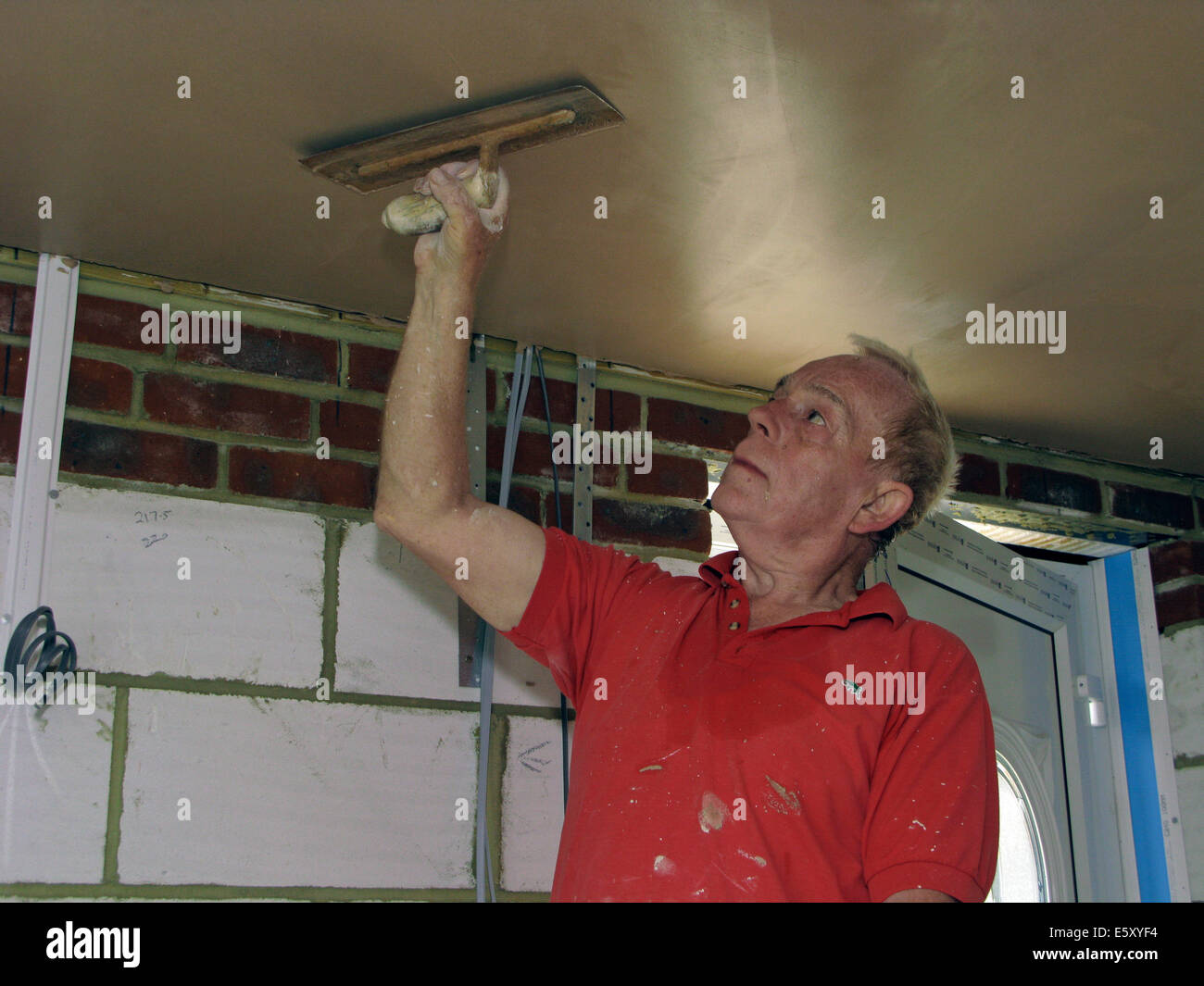 Plasterer plastering the ceiling of a newly built property / extension ...
