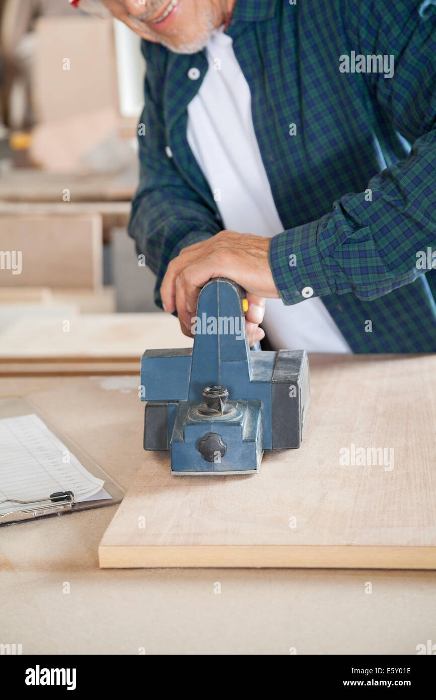 Carpenter Working With Electric Planer In Workshop Stock Photo - Alamy