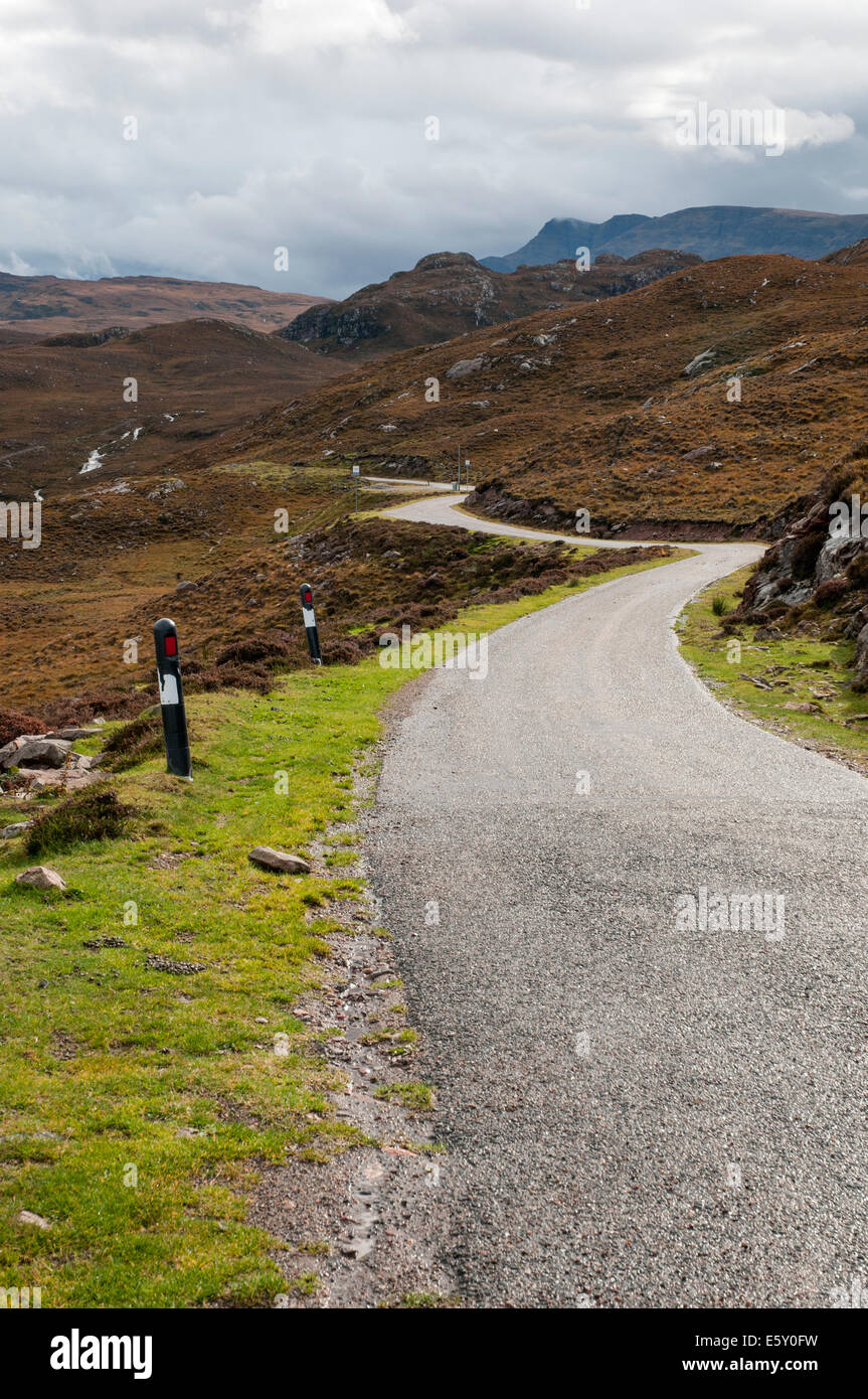 A small winding road shown weaving through the rocky landscape of ...