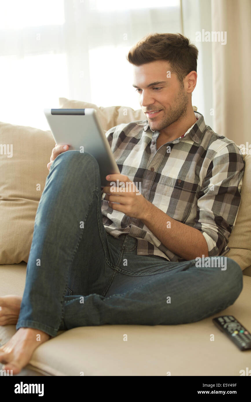Young man using digital tablet at home Stock Photo - Alamy