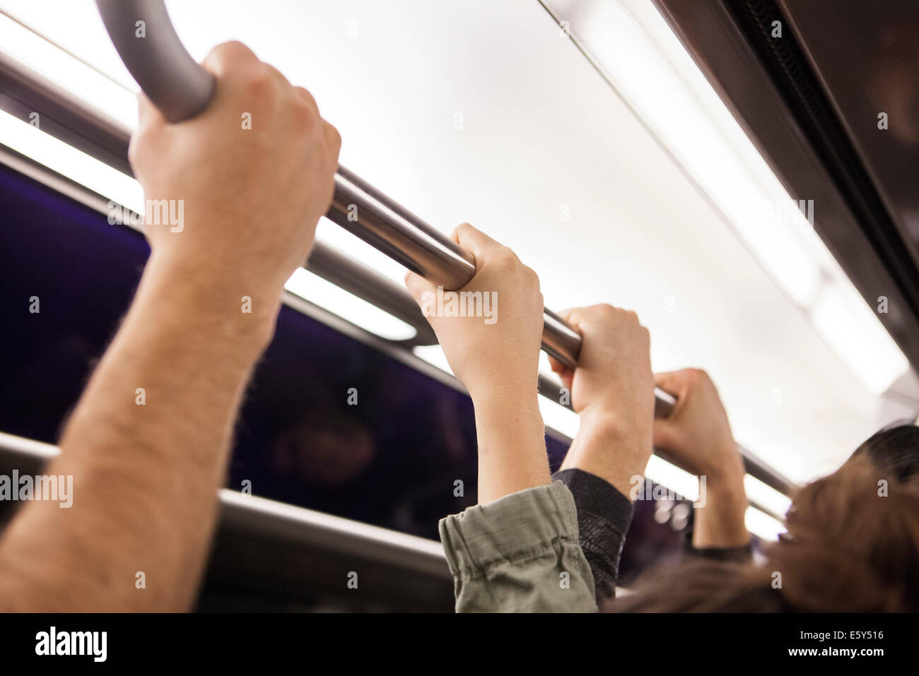 Communters on subway holding grab handle, close-up Stock Photo - Alamy