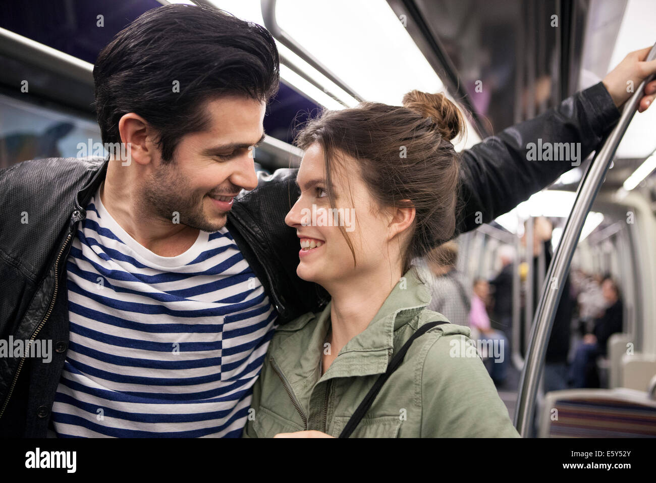 Young couple riding subway together Stock Photo - Alamy