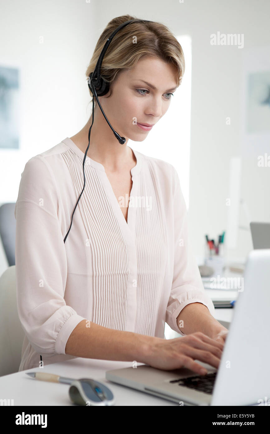 Women headset typing hi-res stock photography and images - Alamy