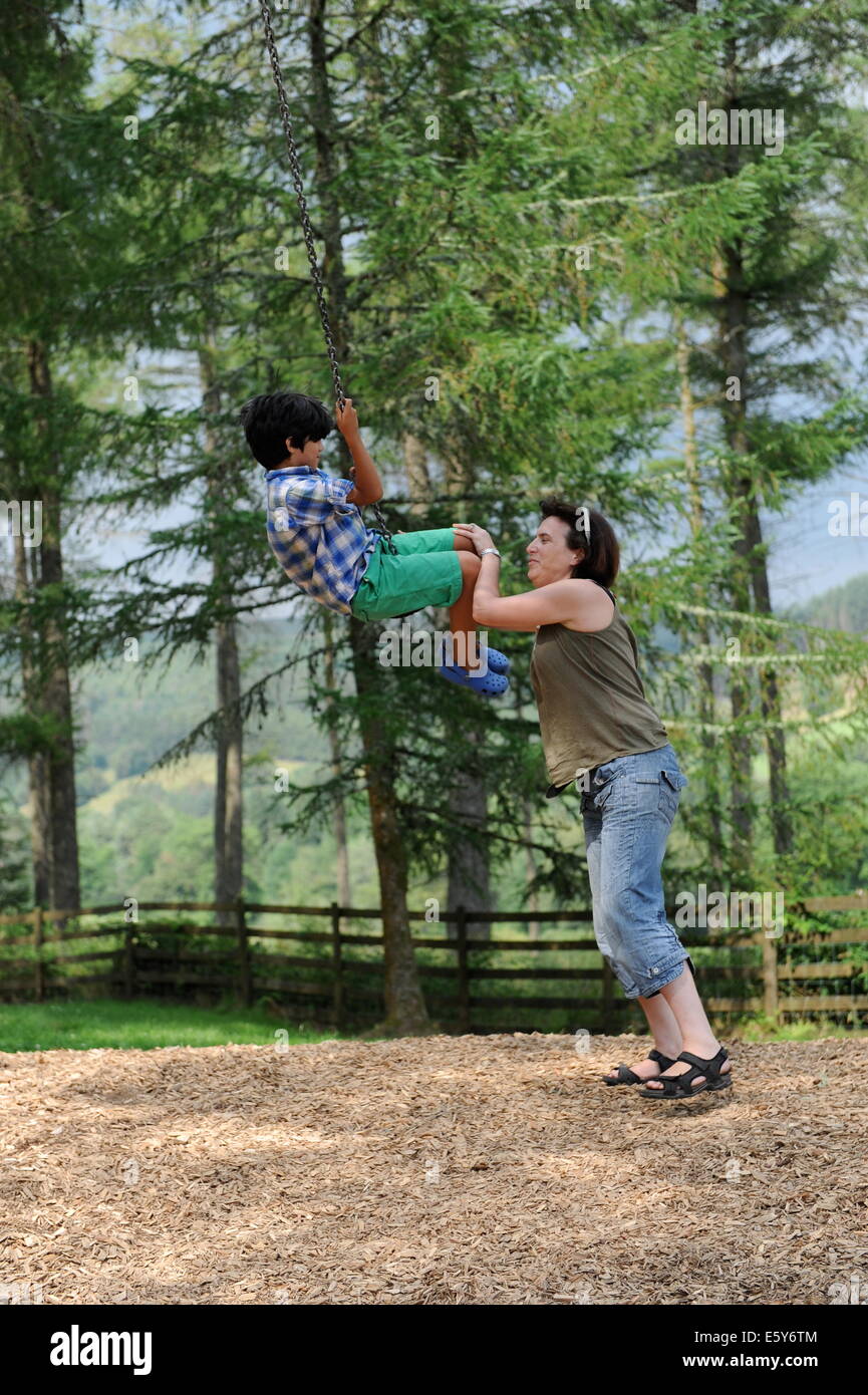 School friends swinging in the adventure park at Garwnant Forest, Powys ...
