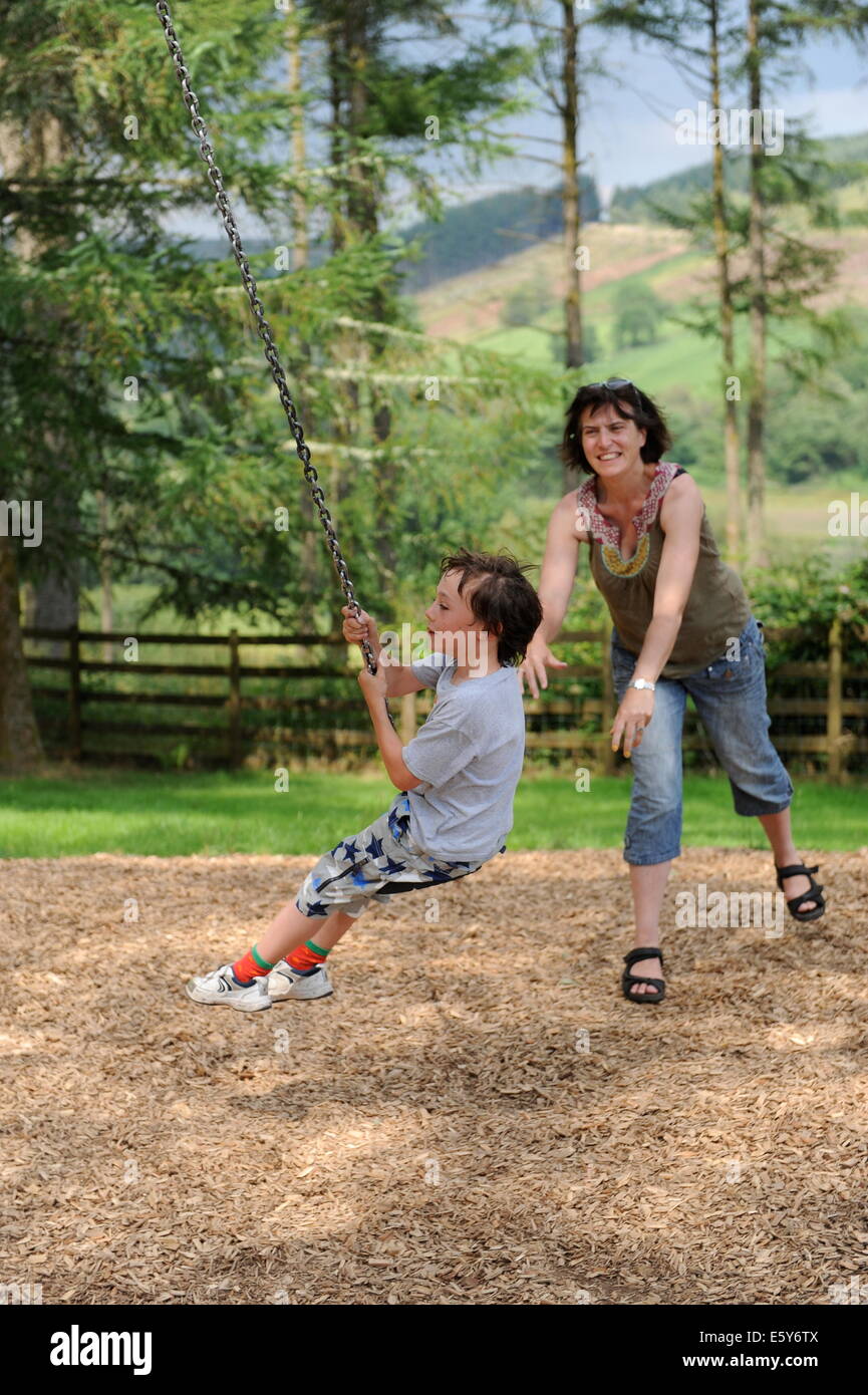 School friends swinging in the adventure park at Garwnant Forest, Powys ...
