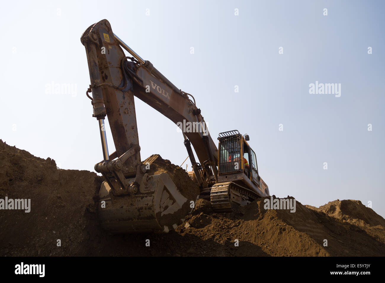A small excavator waits to load trucks at a large open cast copper mine ...