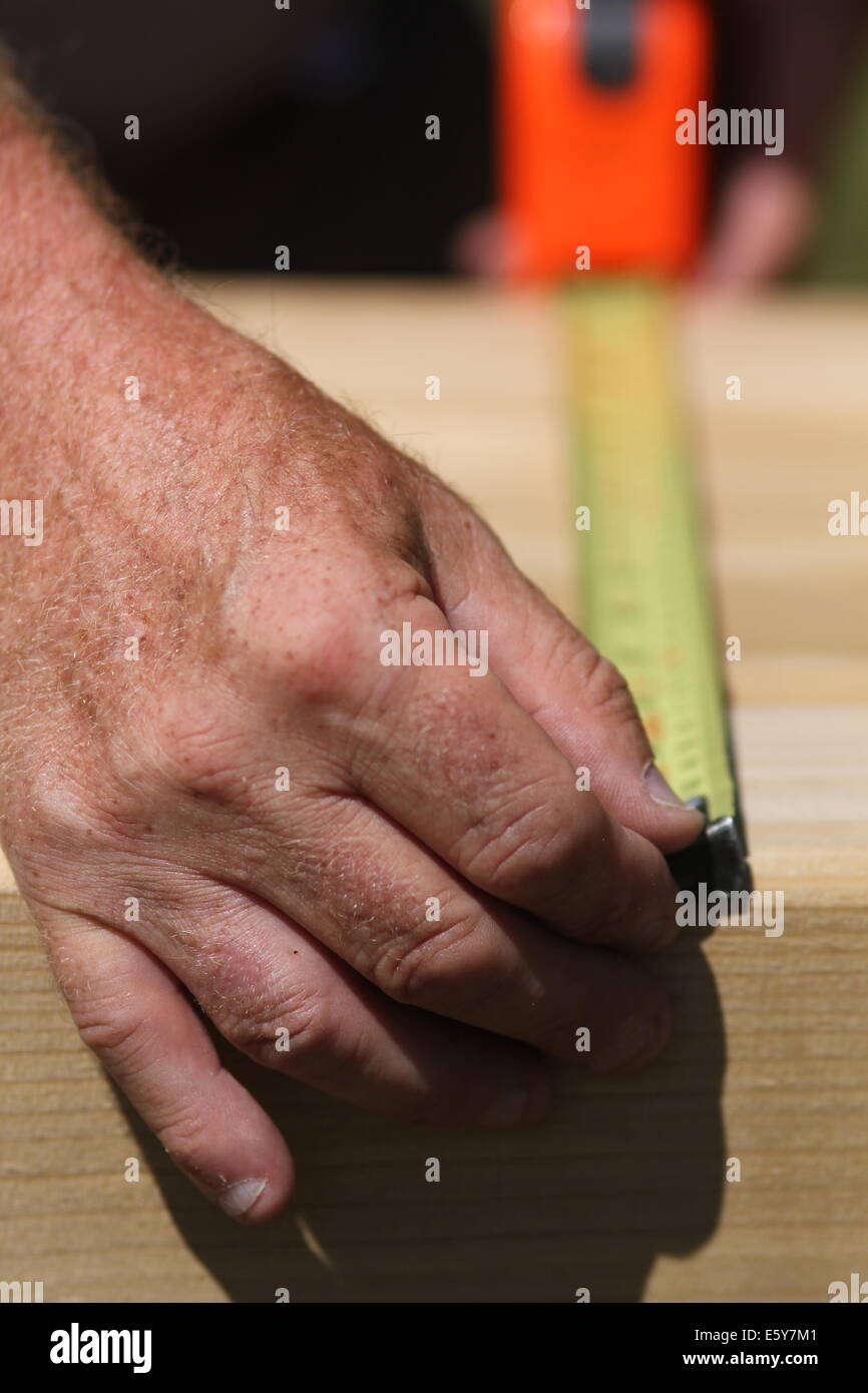 A man working measuring wood Stock Photo - Alamy