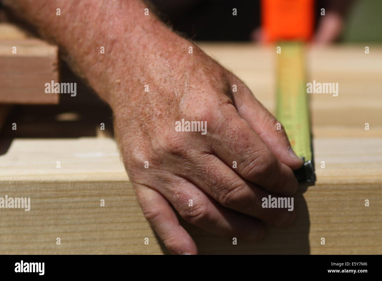 A man working measuring wood Stock Photo - Alamy