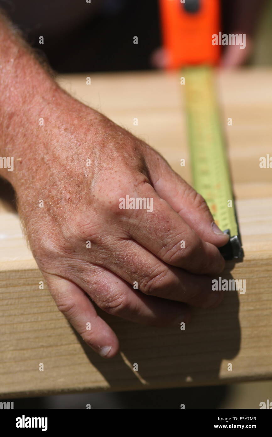 A man working measuring wood Stock Photo - Alamy