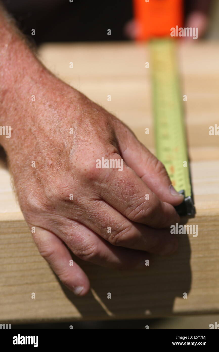 A man working measuring wood Stock Photo - Alamy