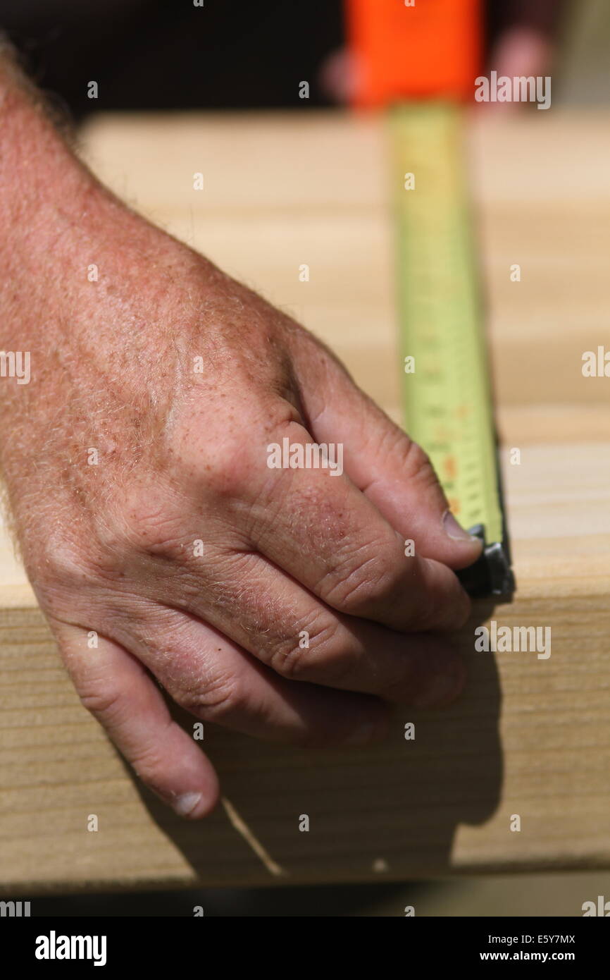 A man working measuring wood Stock Photo - Alamy