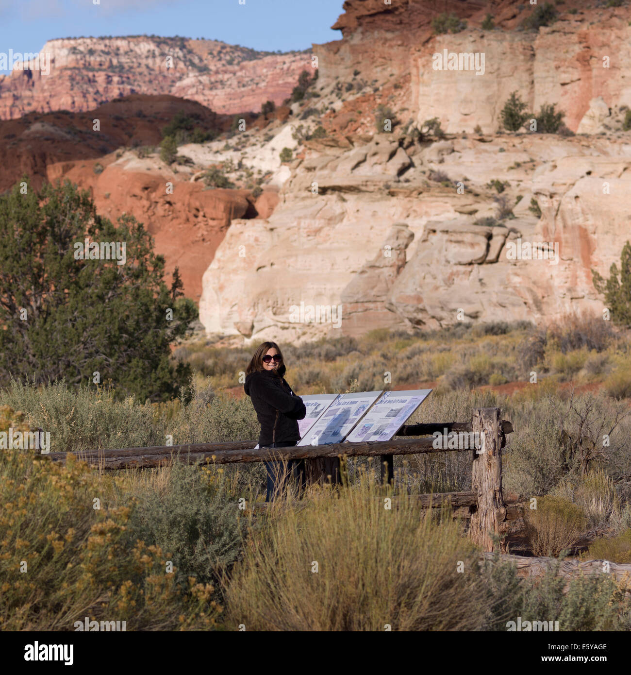 Female tourist standing in a desert near guide maps, Paria Canyon ...