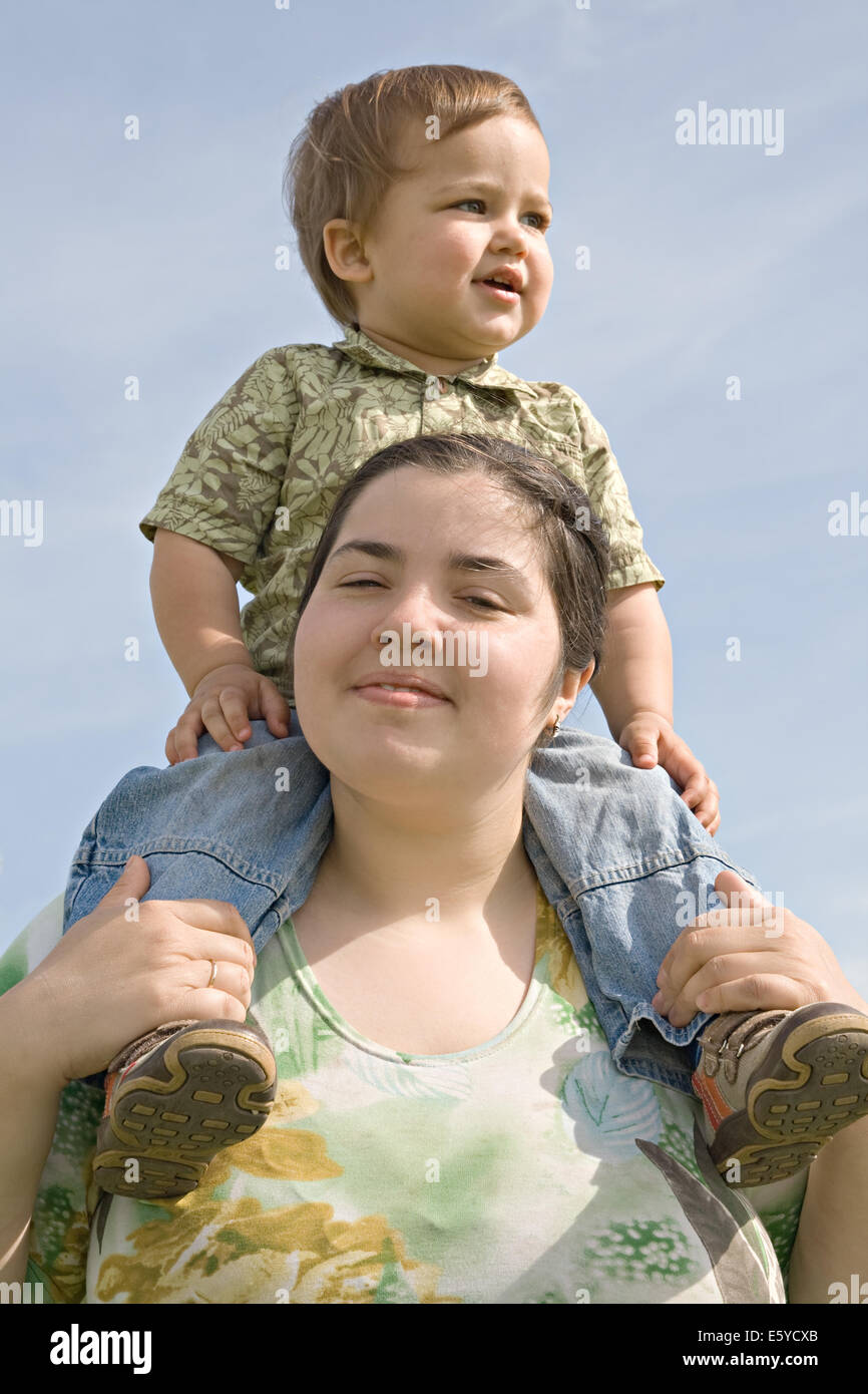 Woman holding her little child on back Stock Photo - Alamy