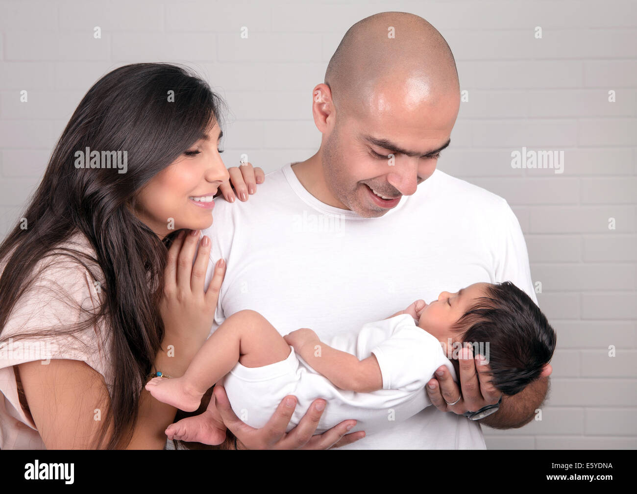 Young happy parents looking on their little newborn baby, having fun at ...