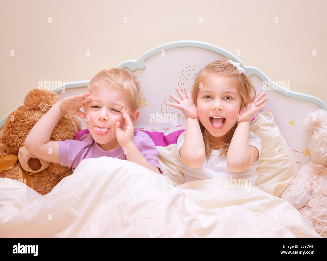 Happy kids make faces, cute brother and sister make grimace, having fun ...