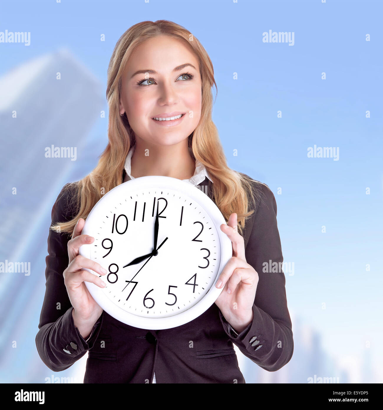 Portrait of happy smiling business woman holding in hands big clock ...