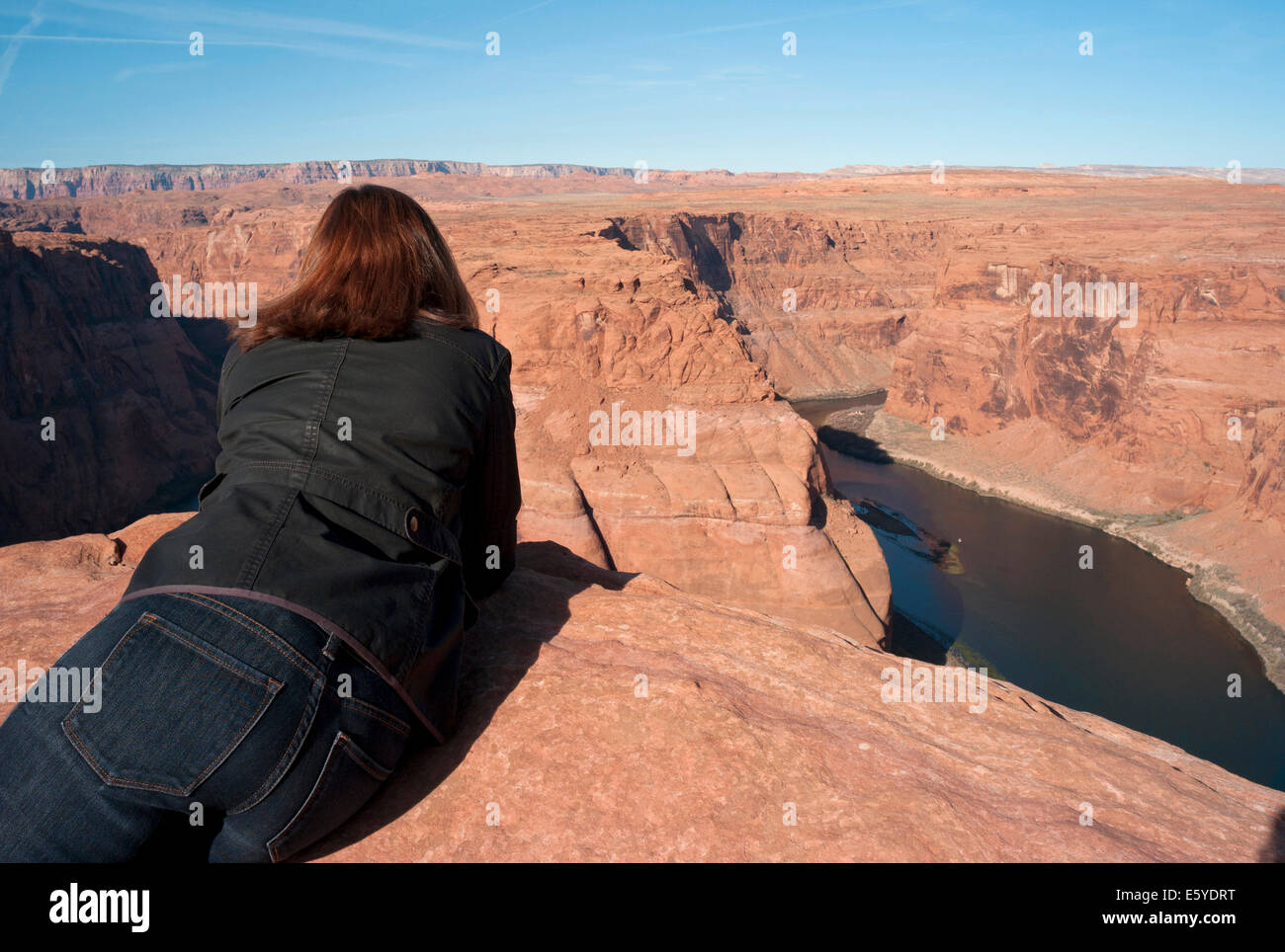 Woman leaning on rock looking at a view, Horseshoe Bend, Glen Canyon ...