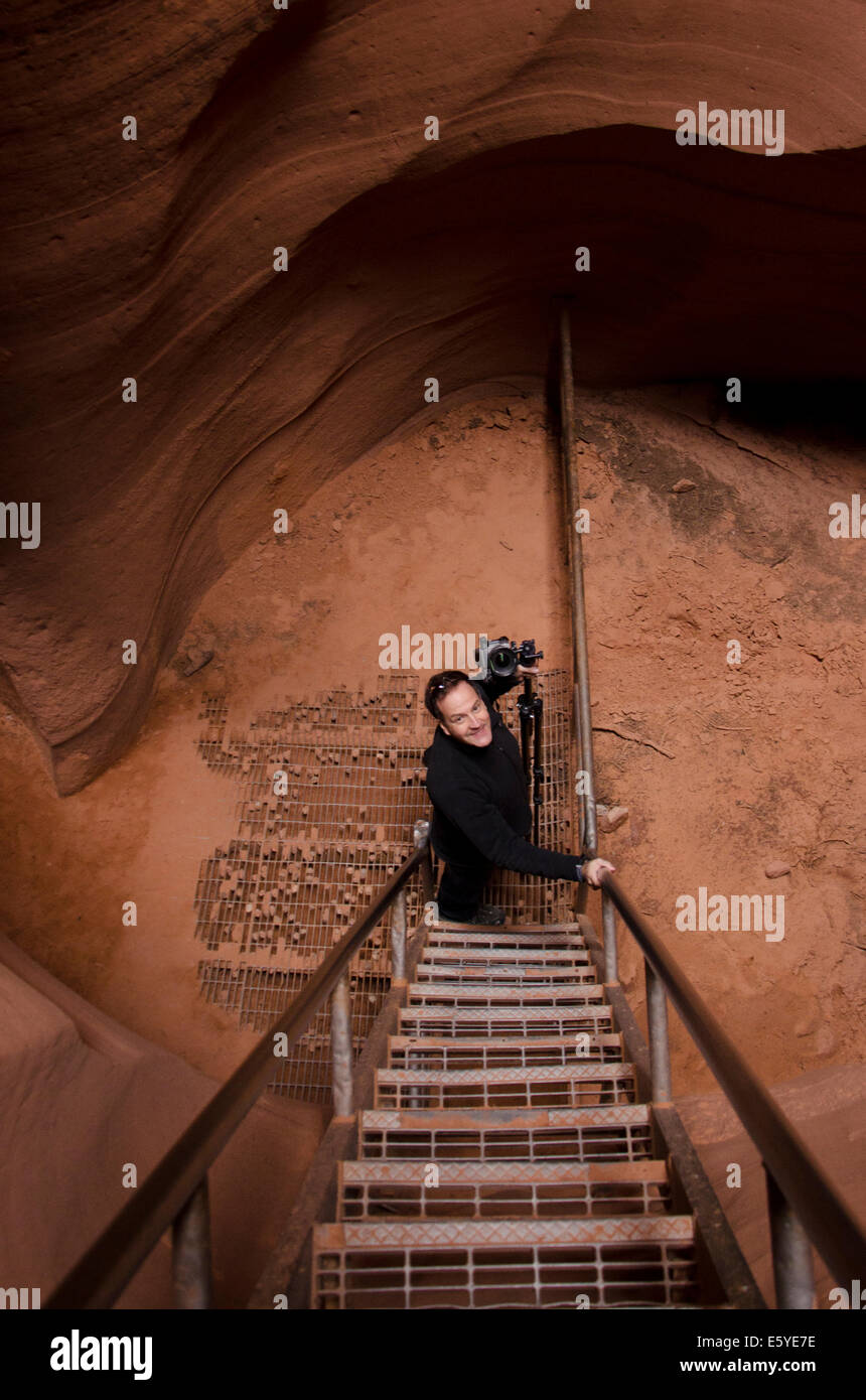 Photographer moving up staircase in a slot canyon, Corkscrew Canyon ...