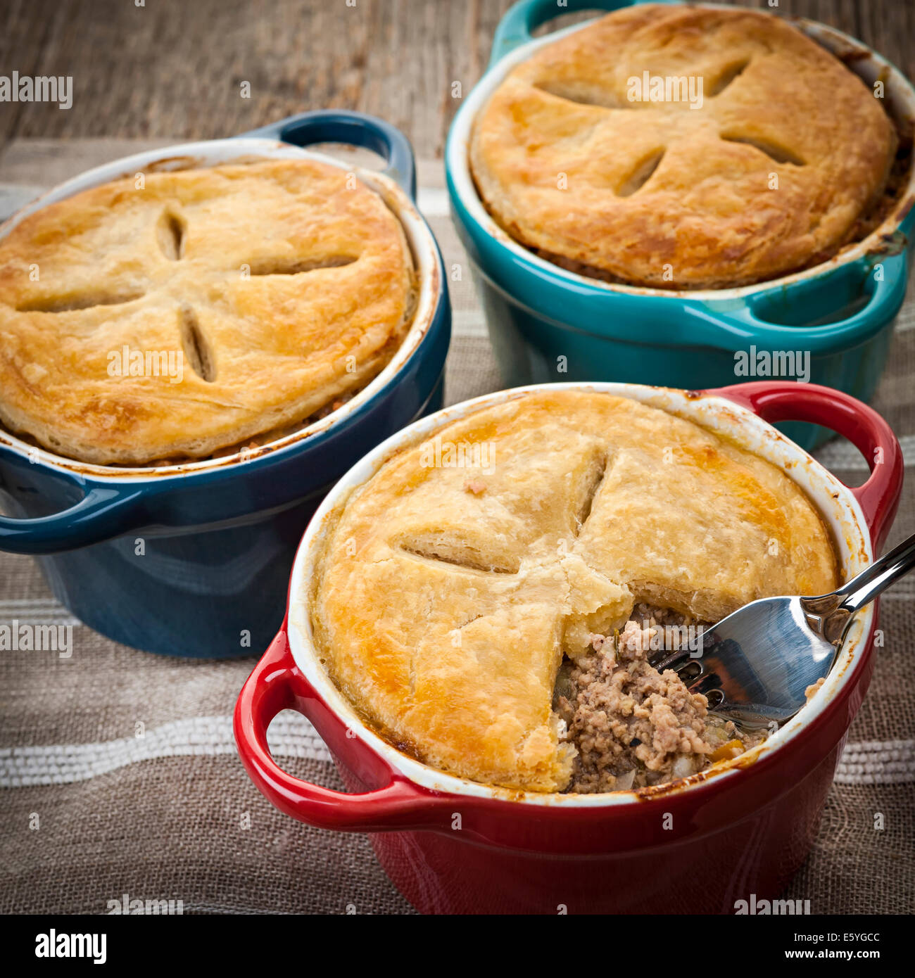 Closeup of three homemade gourmet meat pies with fork showing ground ...