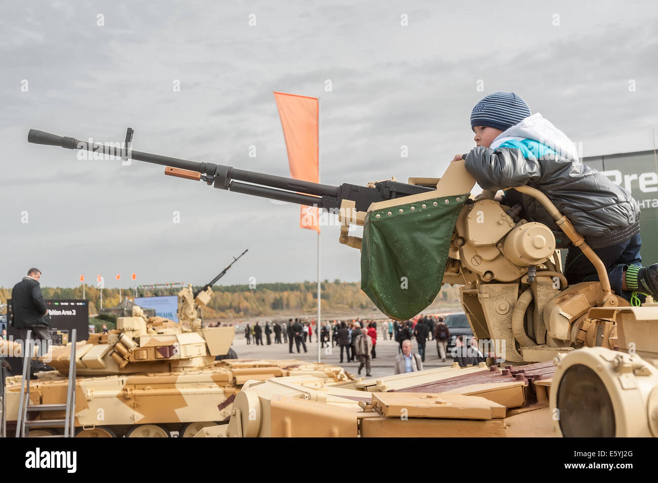 Boy gets acquainted with machine gun Stock Photo - Alamy
