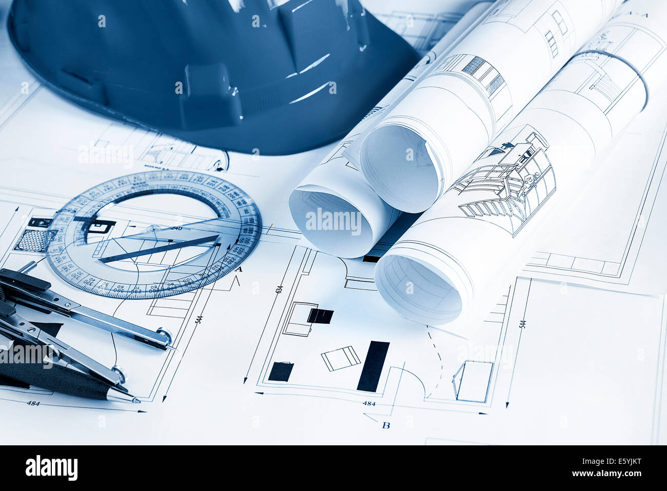 Engineer worplace with blueprints, compass, pen, protractor and safety ...