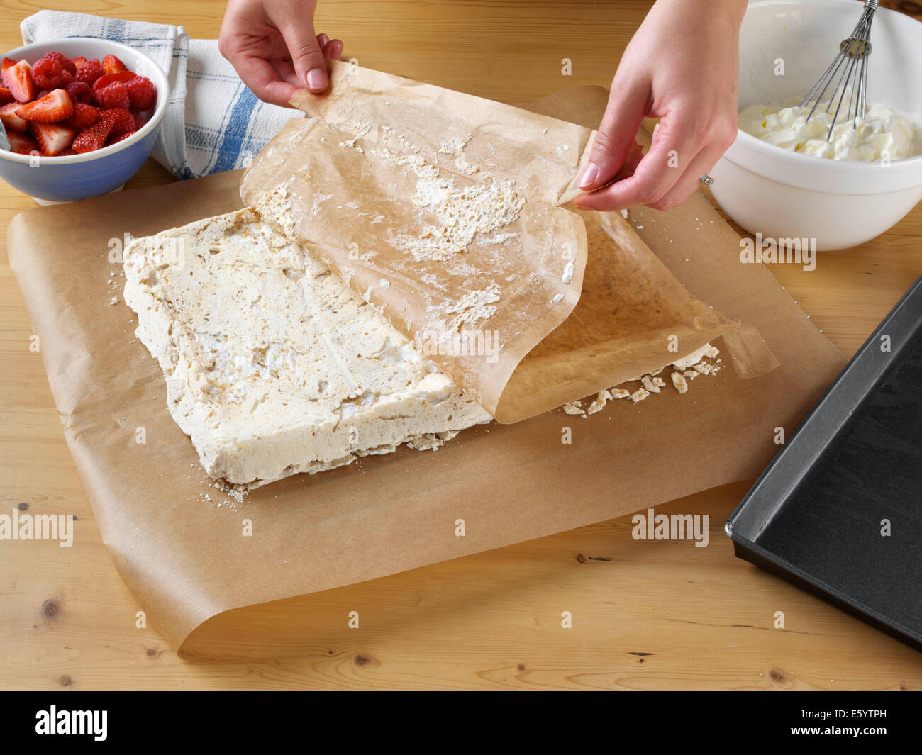 Peeling off baking paper from meringue base Stock Photo - Alamy