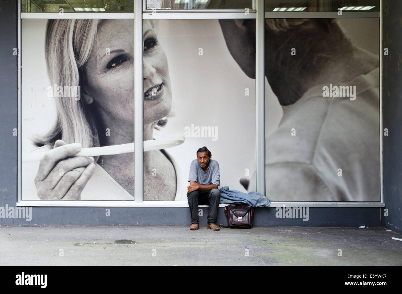Middle class man sitting in front of supply store window containing a ...