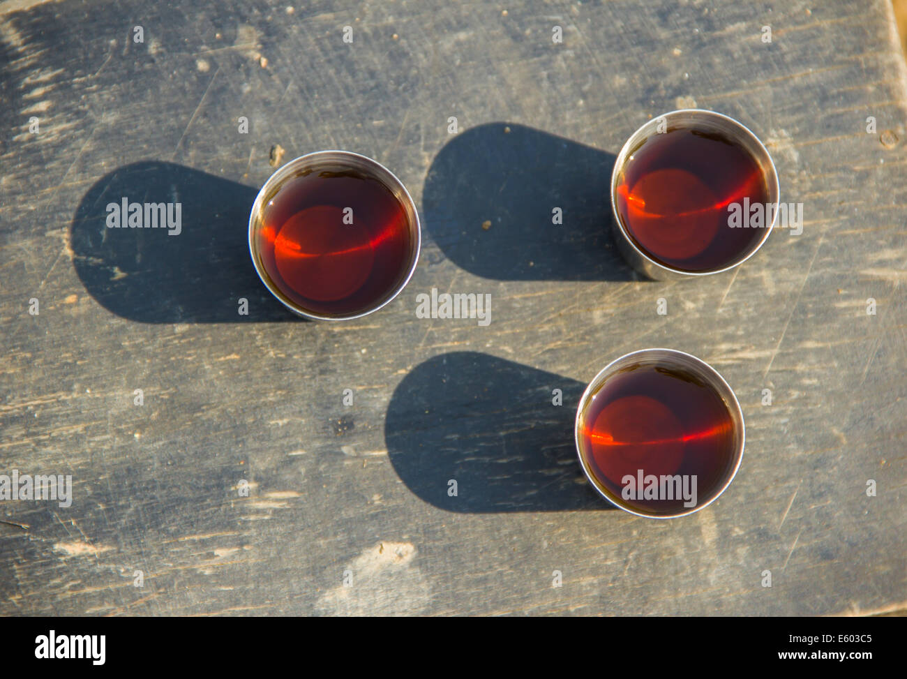 three glasses of alcohol on a wooden board Stock Photo - Alamy